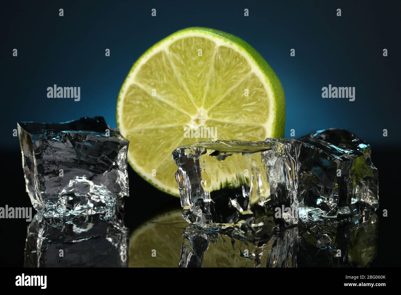 Ice cubes with lime on darck blue background Stock Photo - Alamy