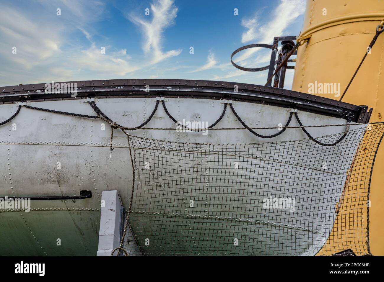 Old fishing net hanging on the white hull of a boat Stock Photo - Alamy