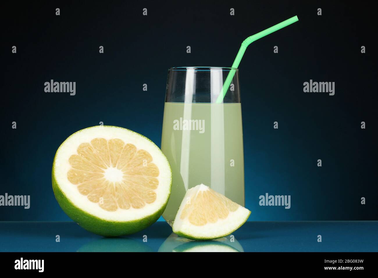 Delicious sweetie juice in glass and sweetie next to it on dark blue ...