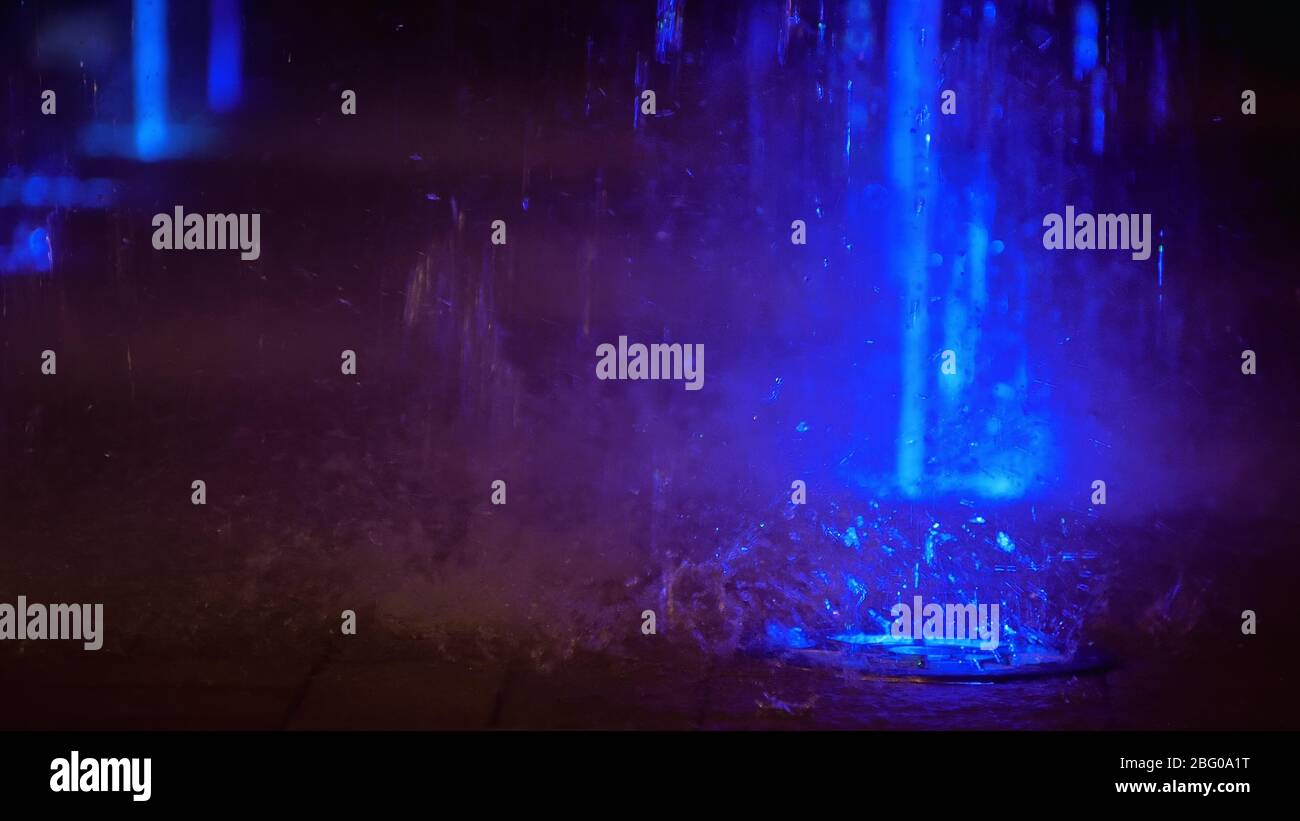 Splashes of colorful fountain. Water illuminated in diverse colors ...
