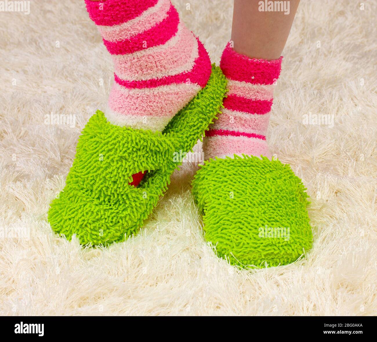 Female legs in color slippers, on carpet background Stock Photo - Alamy