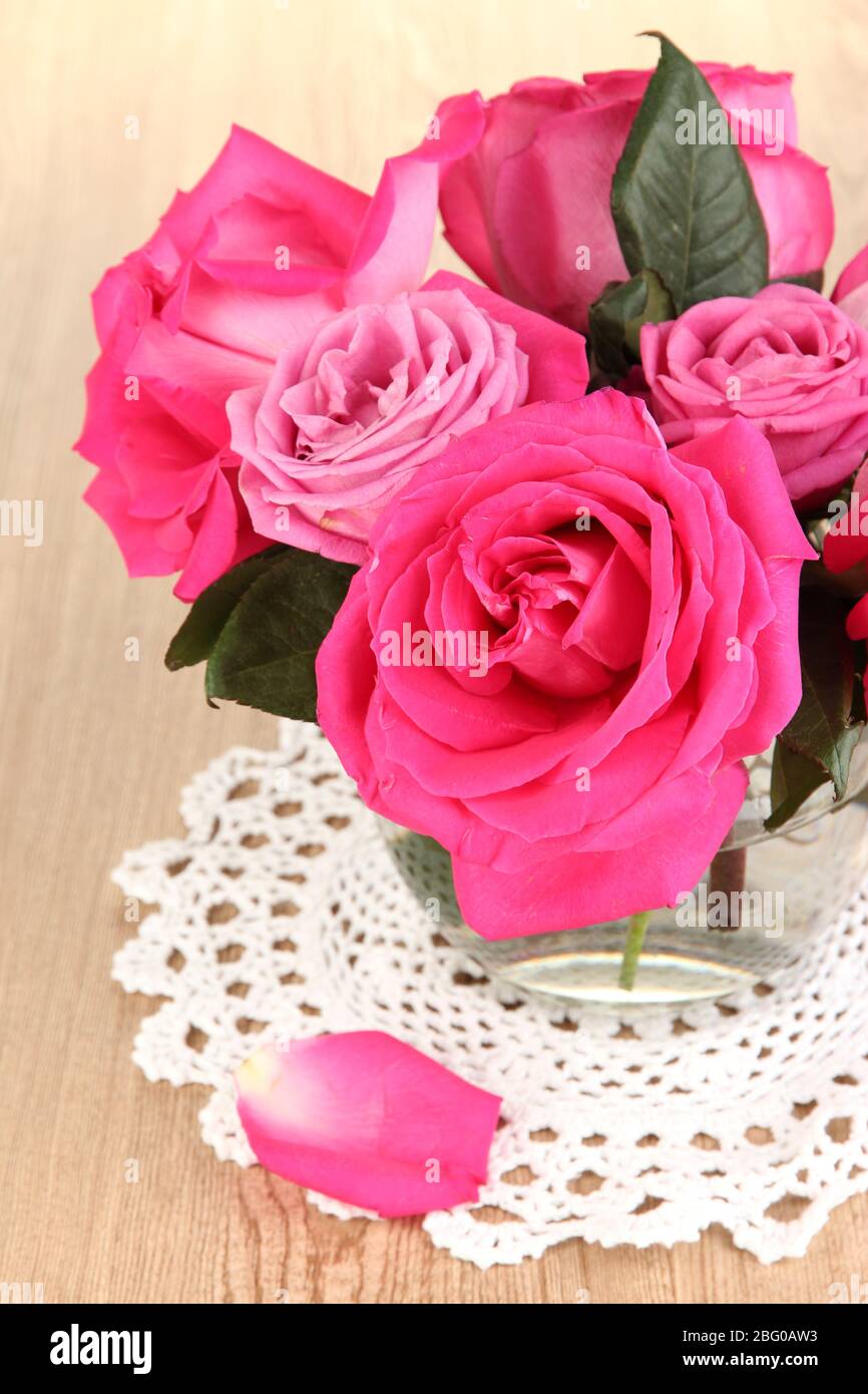 Beautiful pink roses in vase on wooden table close-up Stock Photo - Alamy