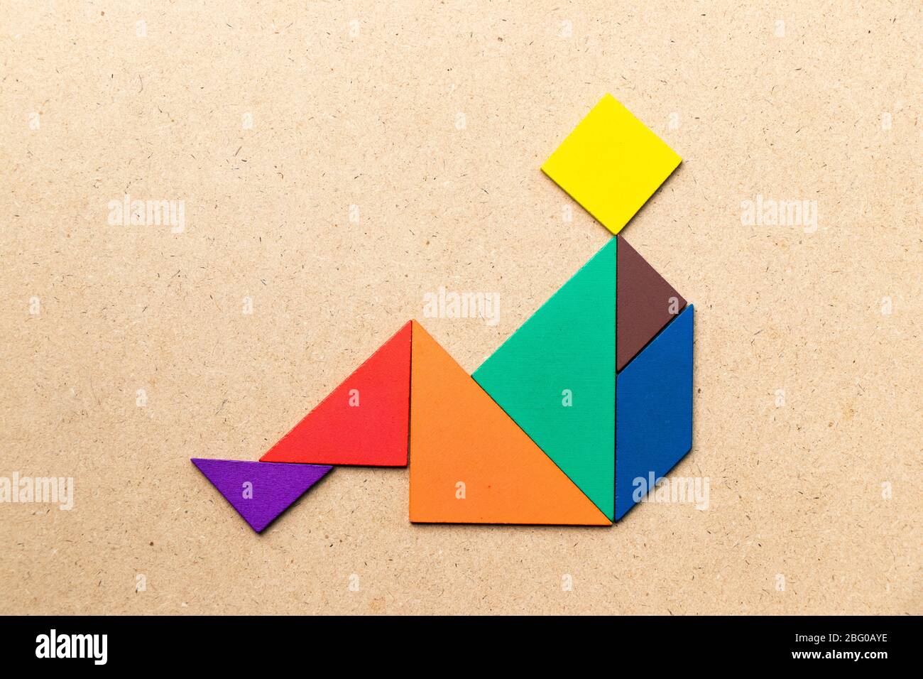 Color tangram in sitting man shape on wood background Stock Photo - Alamy