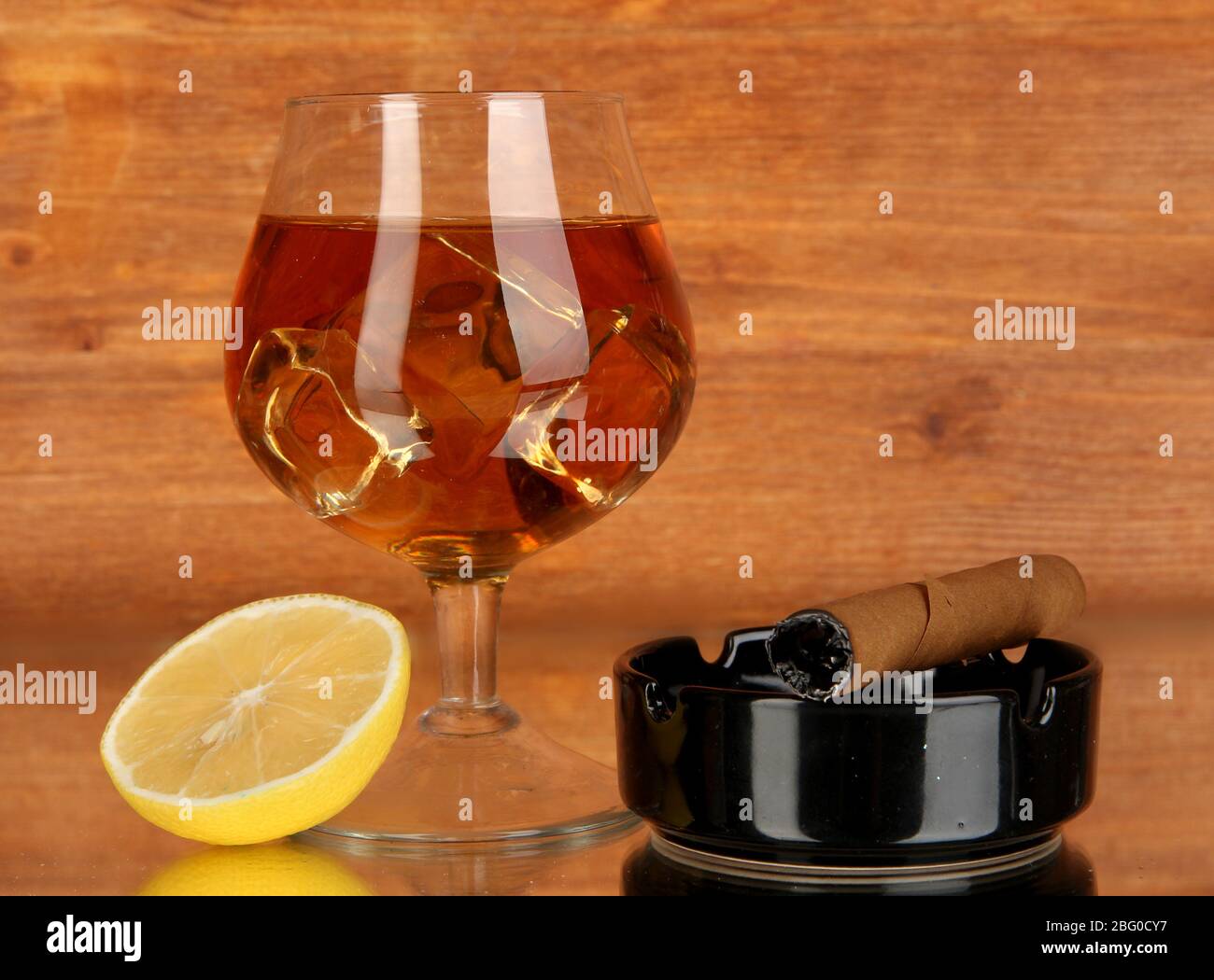 Glass of brandy with ice and lemon on wooden background Stock Photo - Alamy