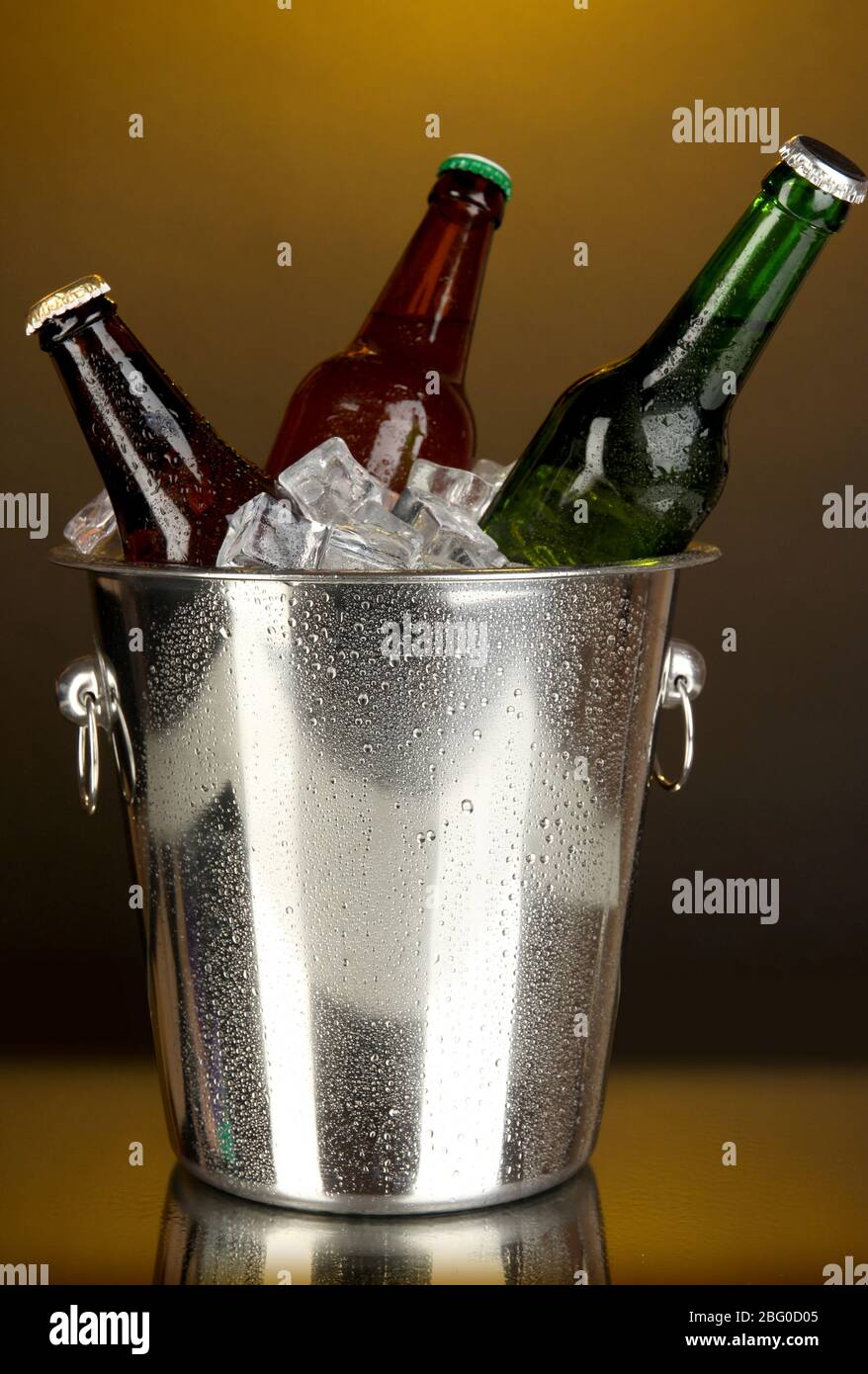 Beer bottles in ice bucket on darck yellow background Stock Photo - Alamy