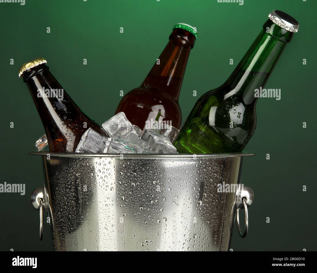 Beer bottles in ice bucket on darck green background Stock Photo - Alamy