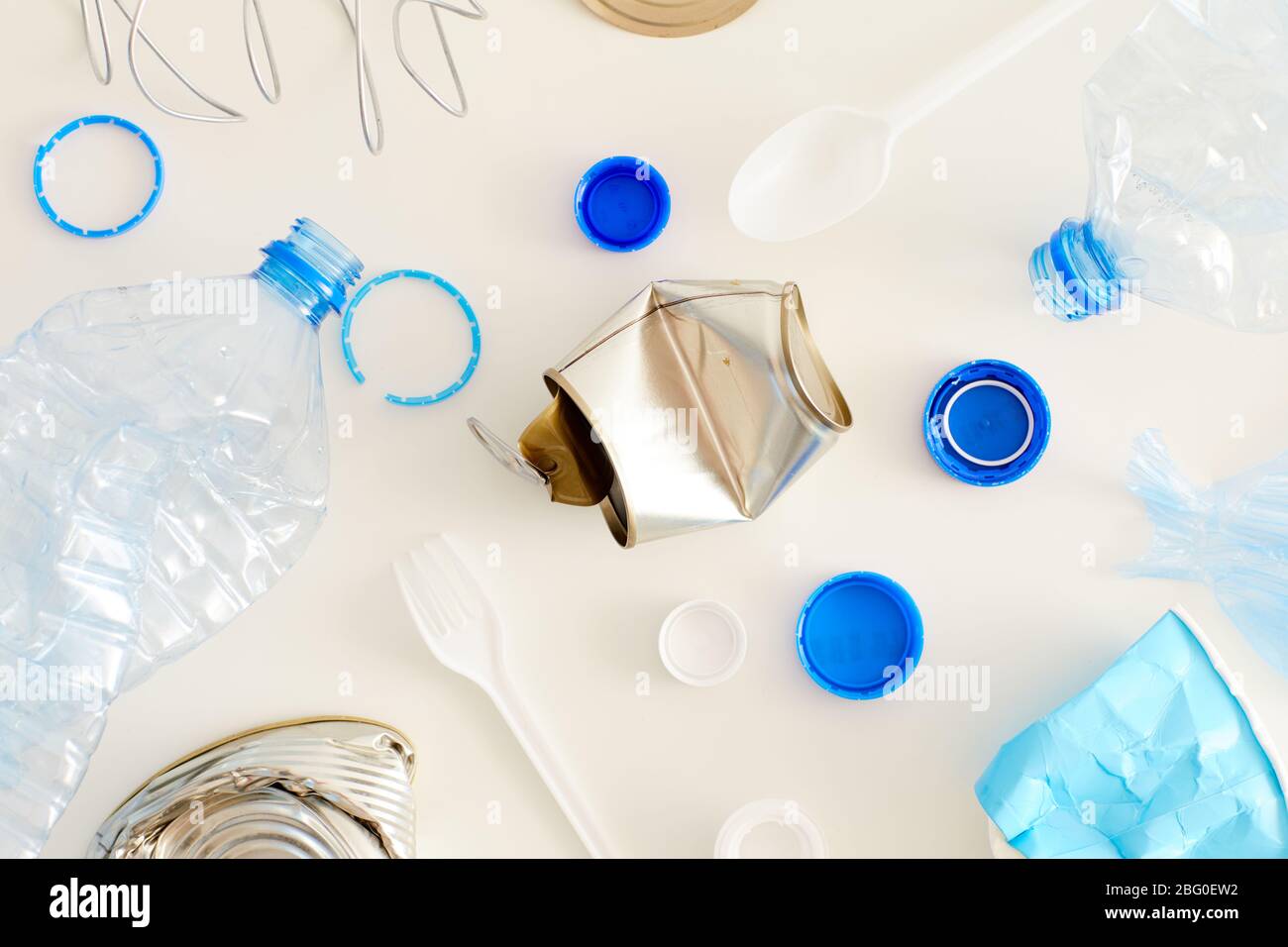 Top view of various trash items laid in minimal composition on white ...