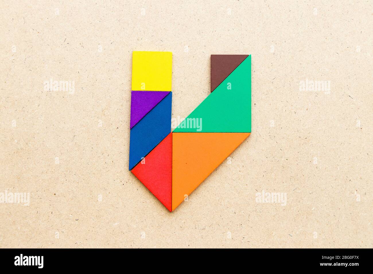 Tangram puzzle in alphabet letter V shape on wood background Stock ...