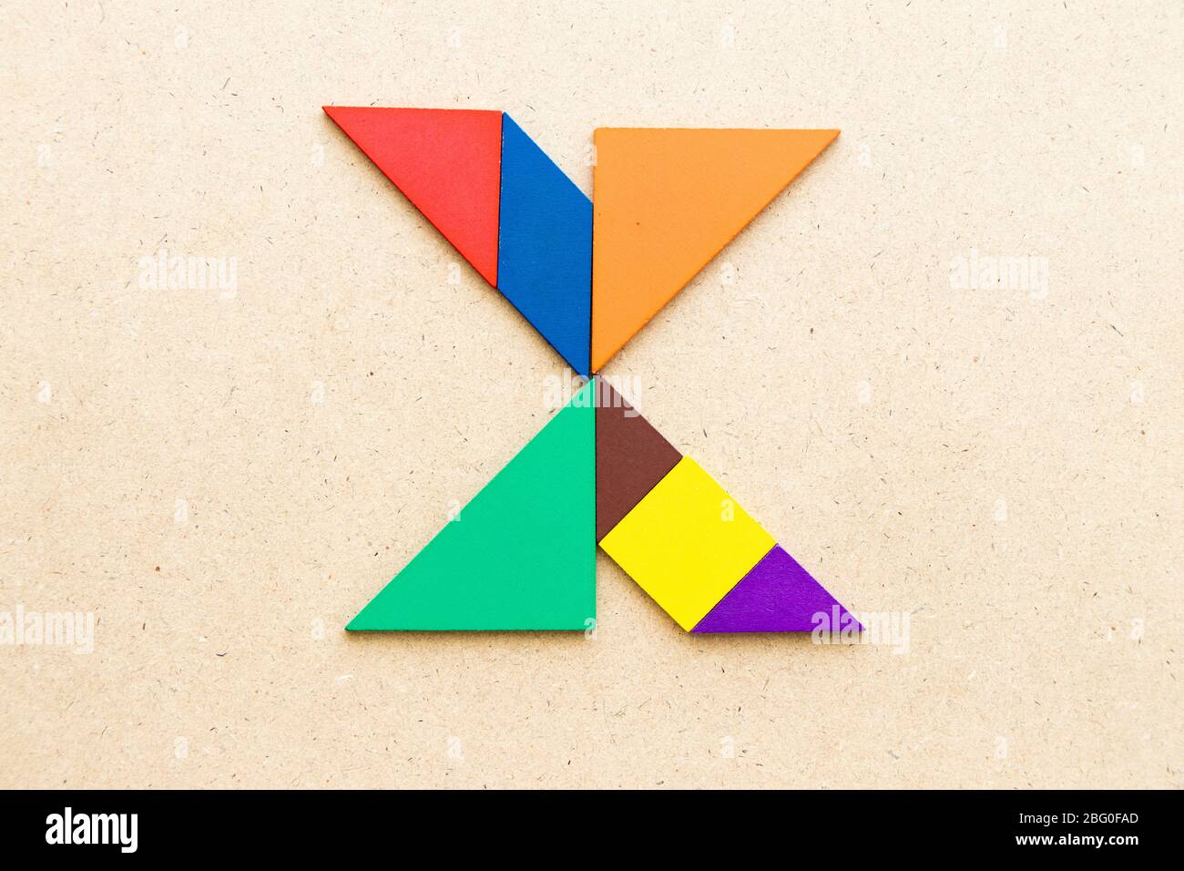 Tangram puzzle in alphabet letter X shape on wood background Stock ...