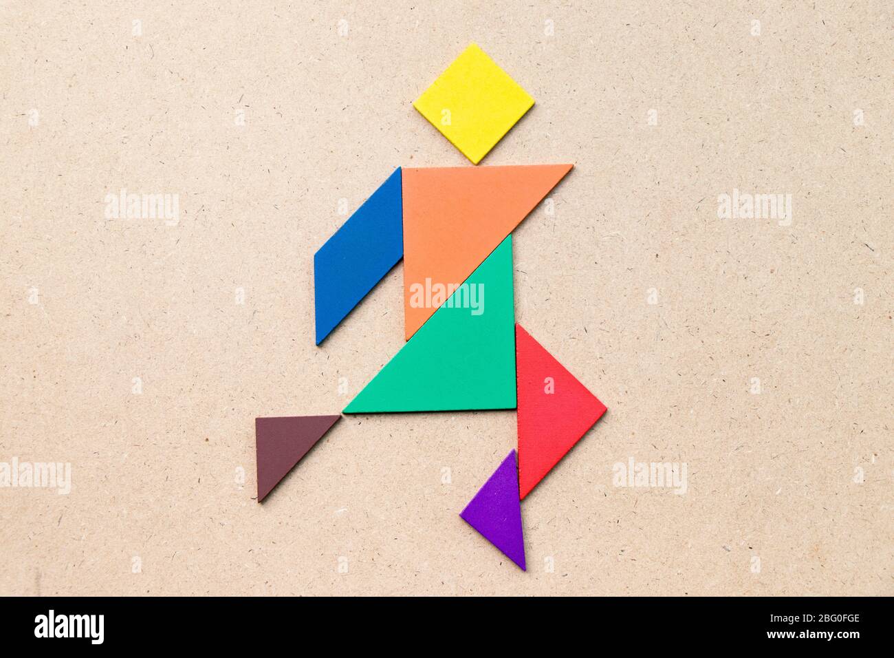 Color tangram in running man shape on wood background Stock Photo - Alamy