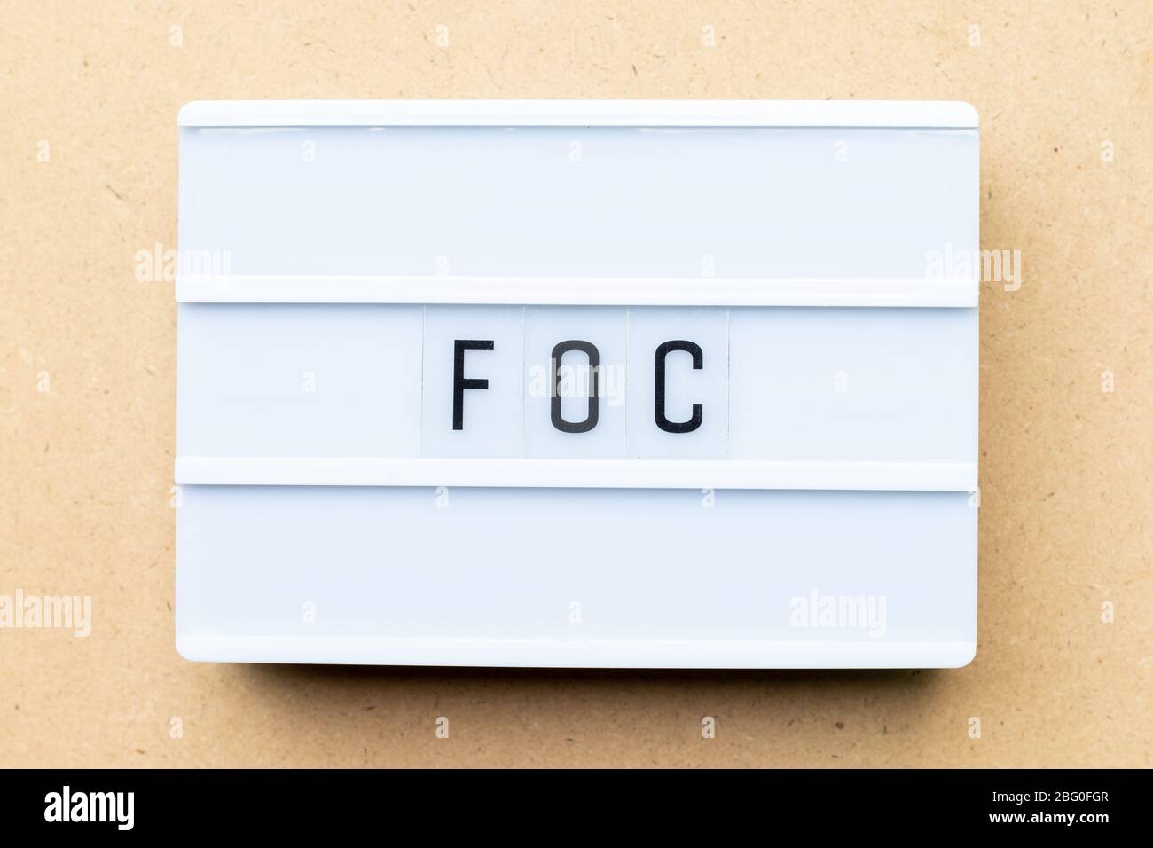 White lightbox with word FOC (Abbreviation of Free of charge) on wood ...