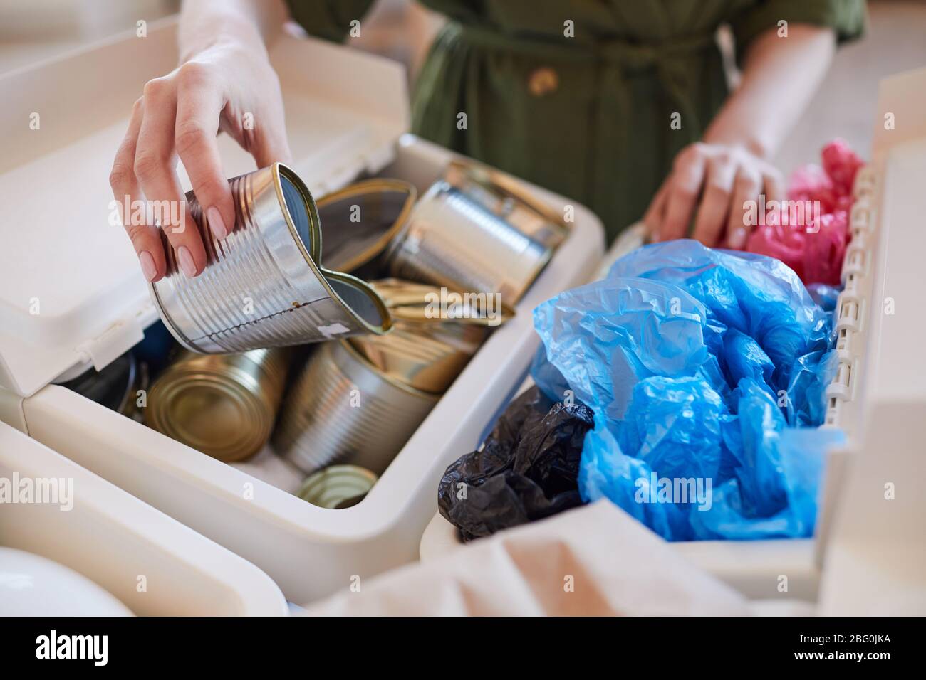 Close up of unrecognizable woman putting discarded metal cans into ...