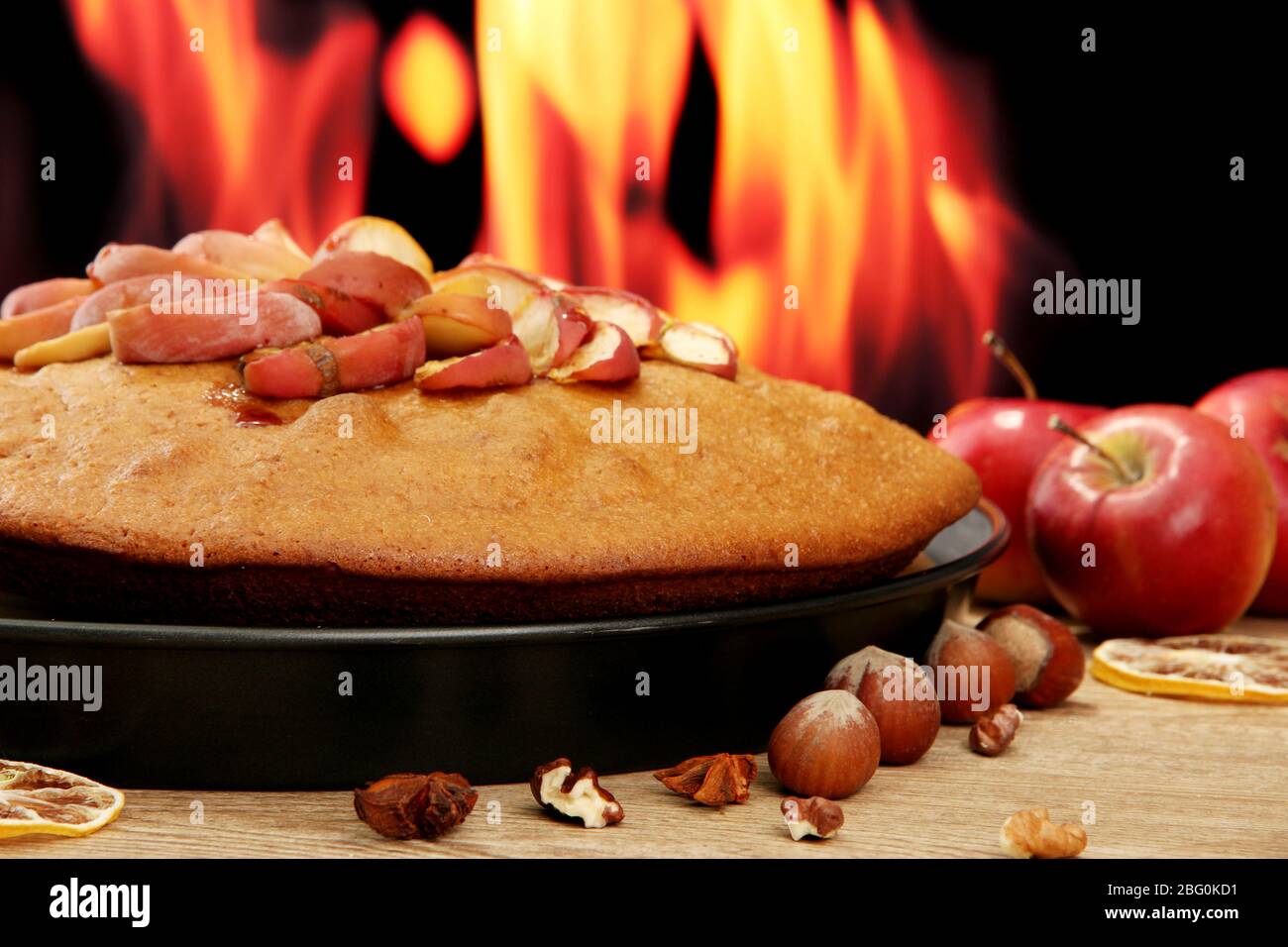 tasty homemade pie with apples and nuts, on wooden table on flame ...