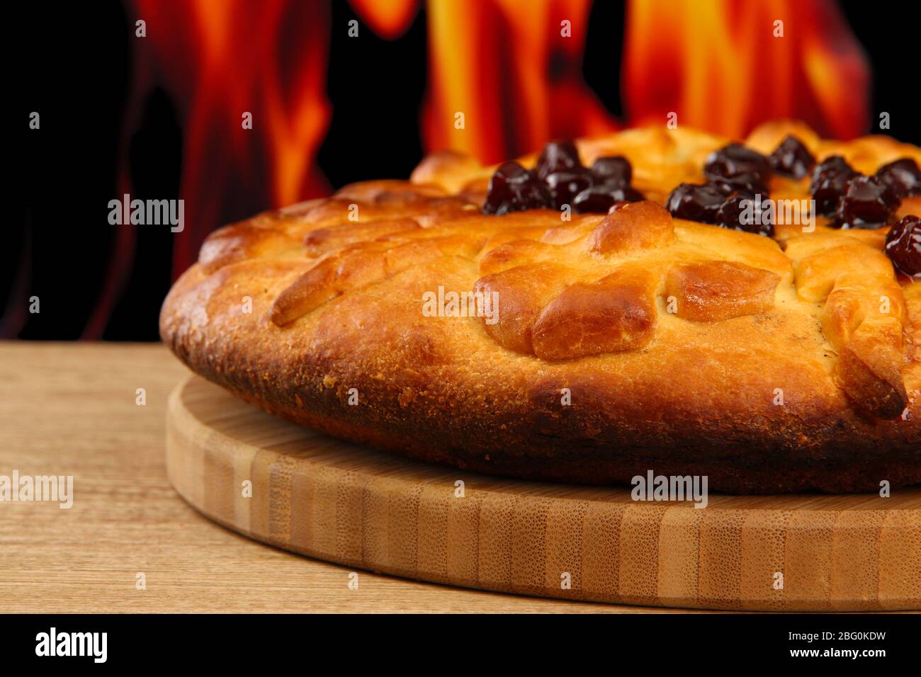 tasty homemade pie with jam, on wooden table on flame background Stock ...