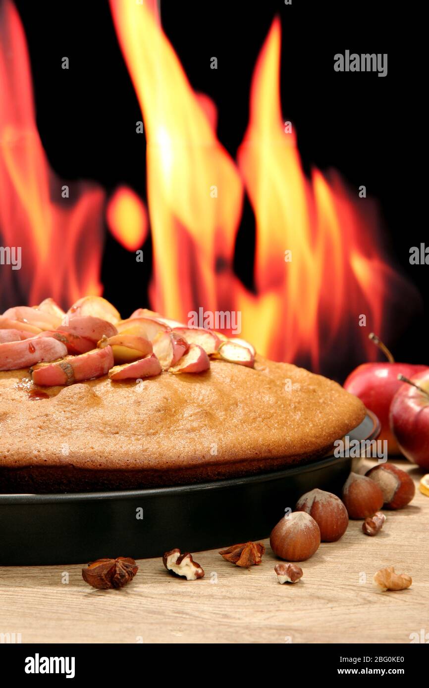 tasty homemade pie with apples and nuts, on wooden table on flame ...