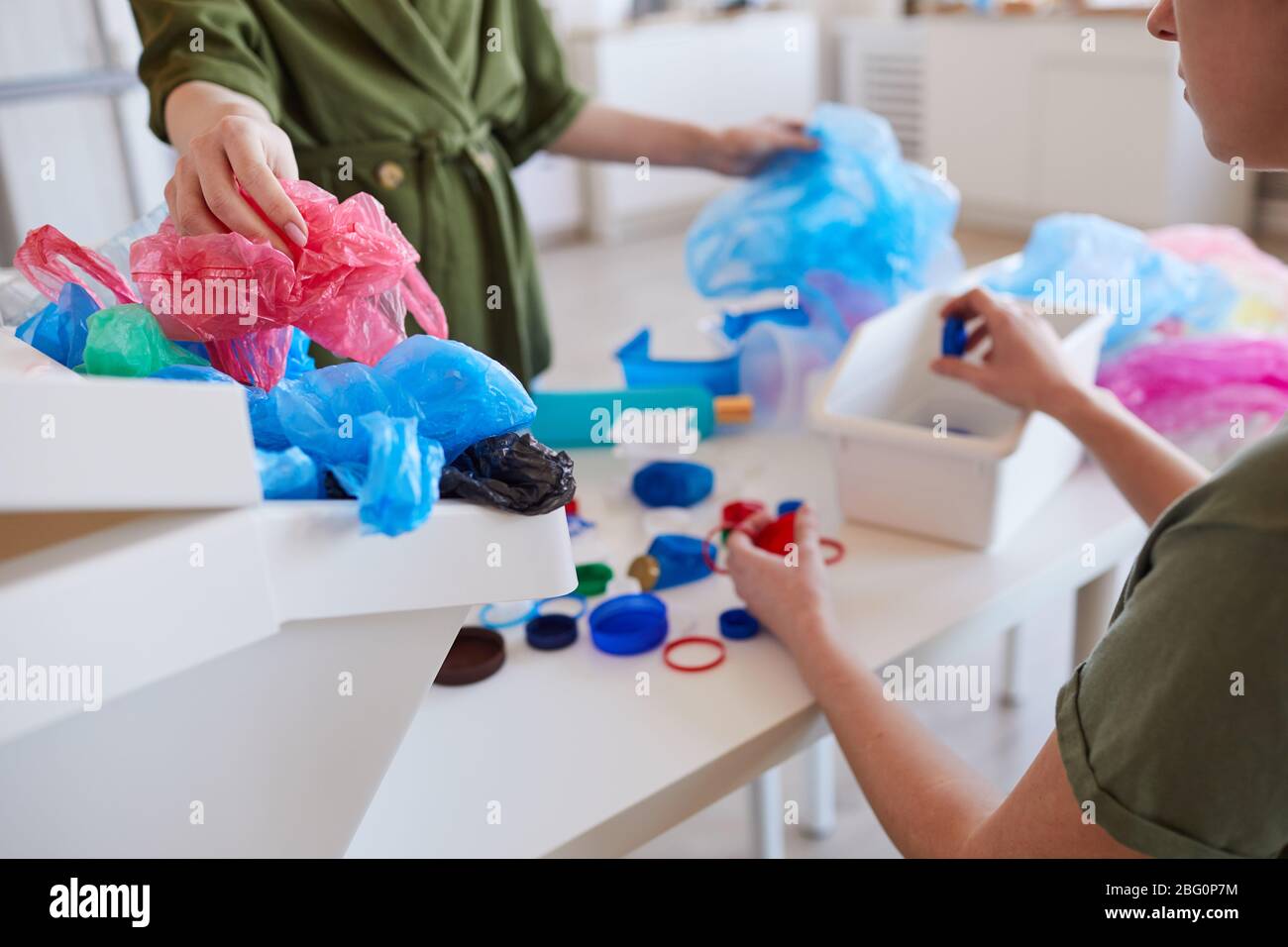 Close up of unrecognizable people sorting plastic waste at home before ...