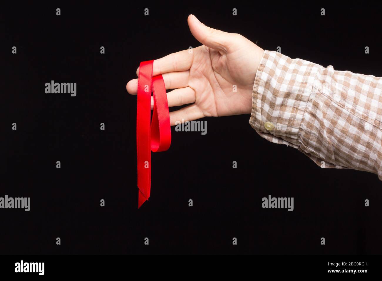 Ribbon to decorate gifts in the hand of an adult person on a plain ...