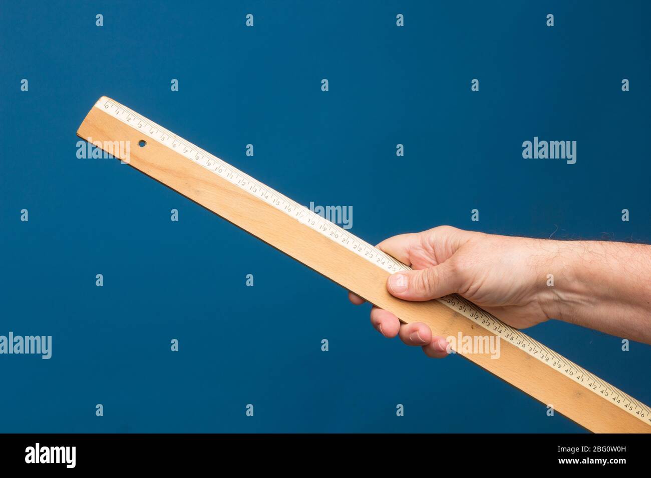 Wooden ruler in a person's hand, a classic vintage ruler of a lifetime ...