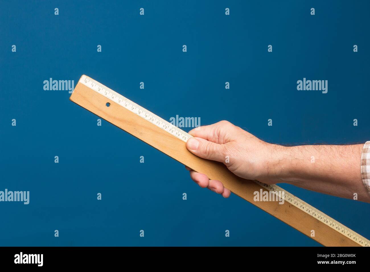 Wooden ruler in a person's hand, a classic vintage ruler of a lifetime ...