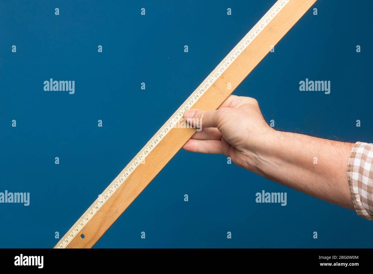 Wooden ruler in a person's hand, a classic vintage ruler of a lifetime ...