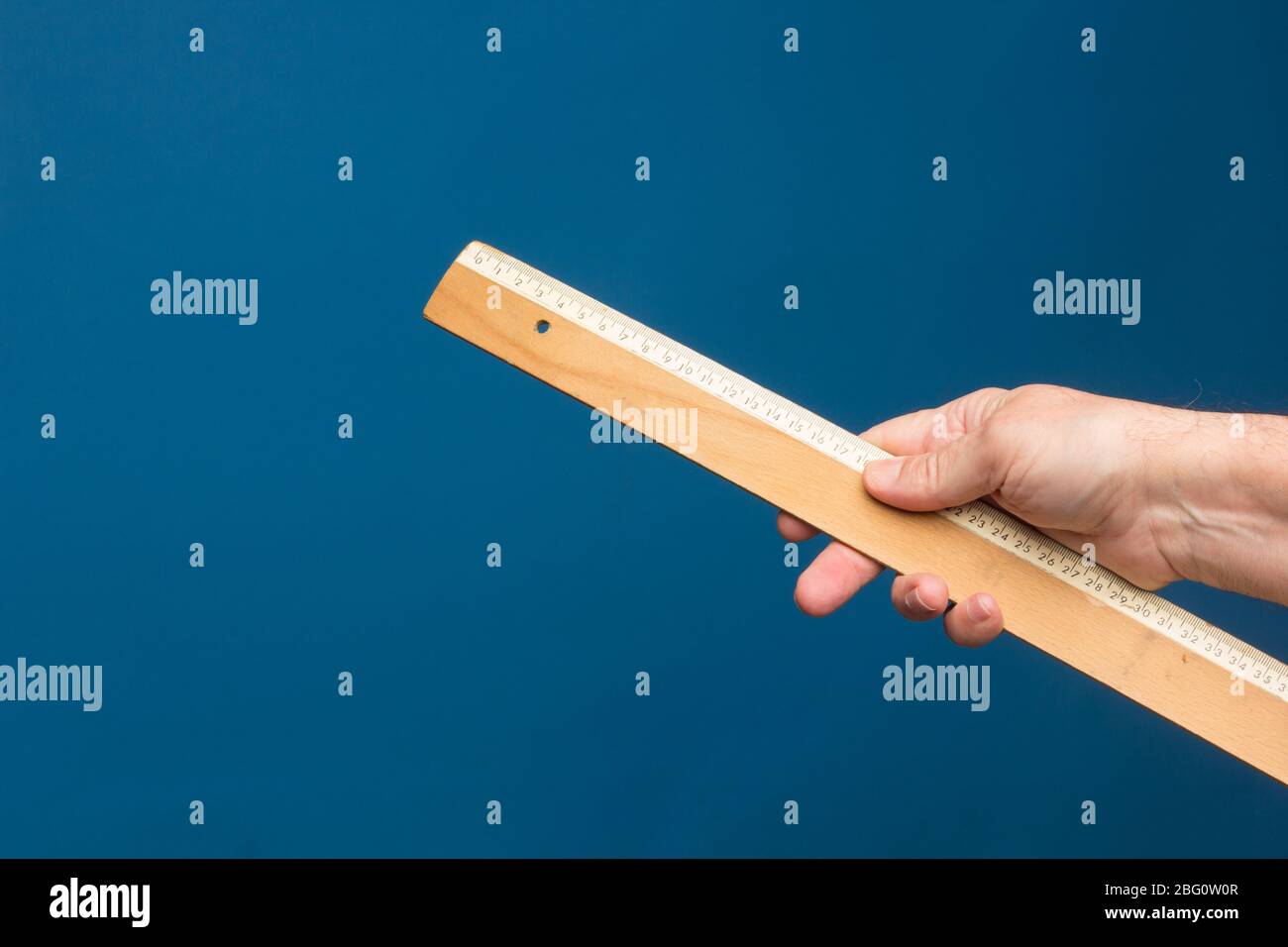 Wooden ruler in a person's hand, a classic vintage ruler of a lifetime ...
