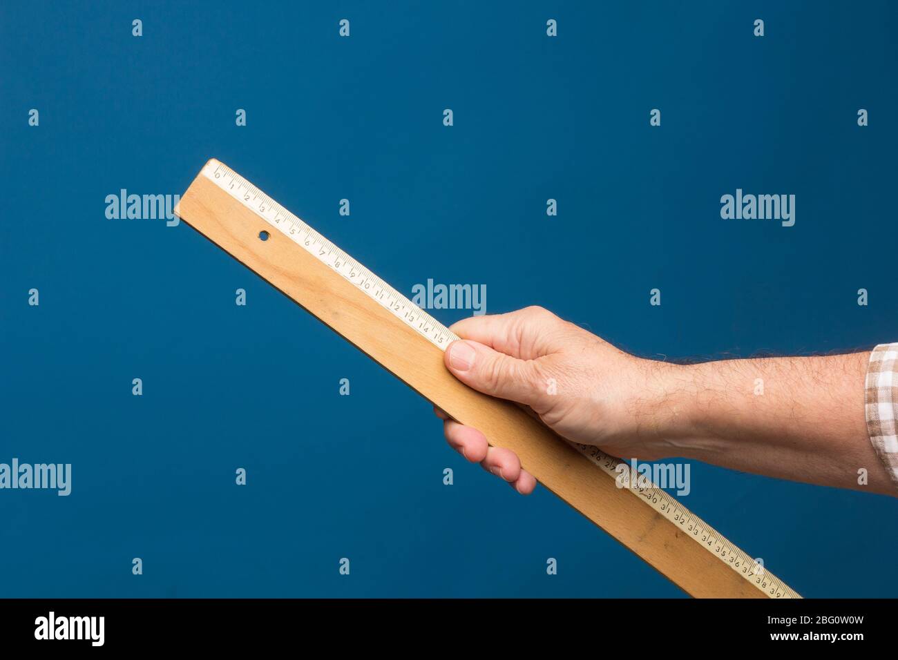 Wooden ruler in a person's hand, a classic vintage ruler of a lifetime ...