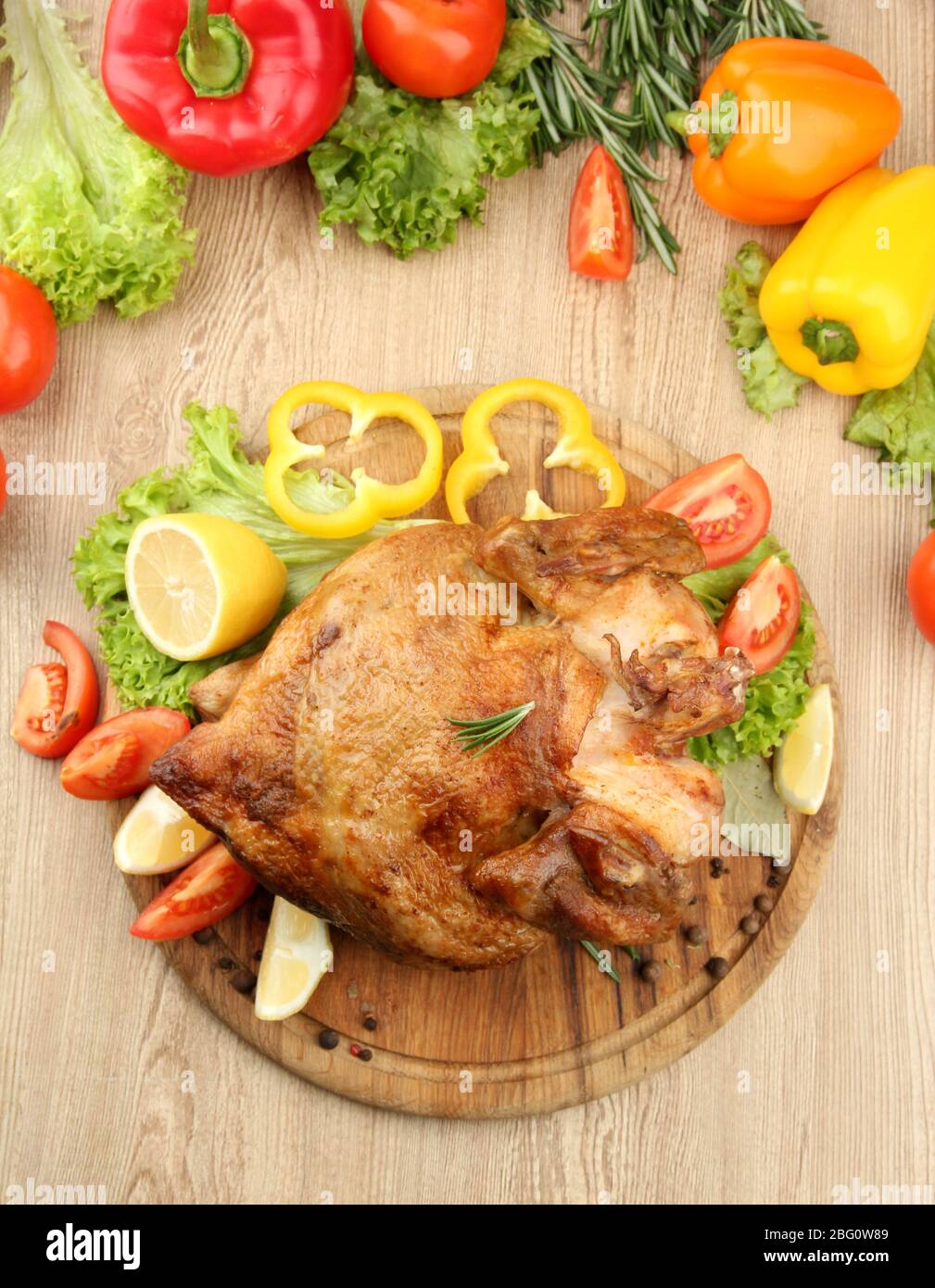 Whole roasted chicken with vegetables on plate, on wooden table Stock ...