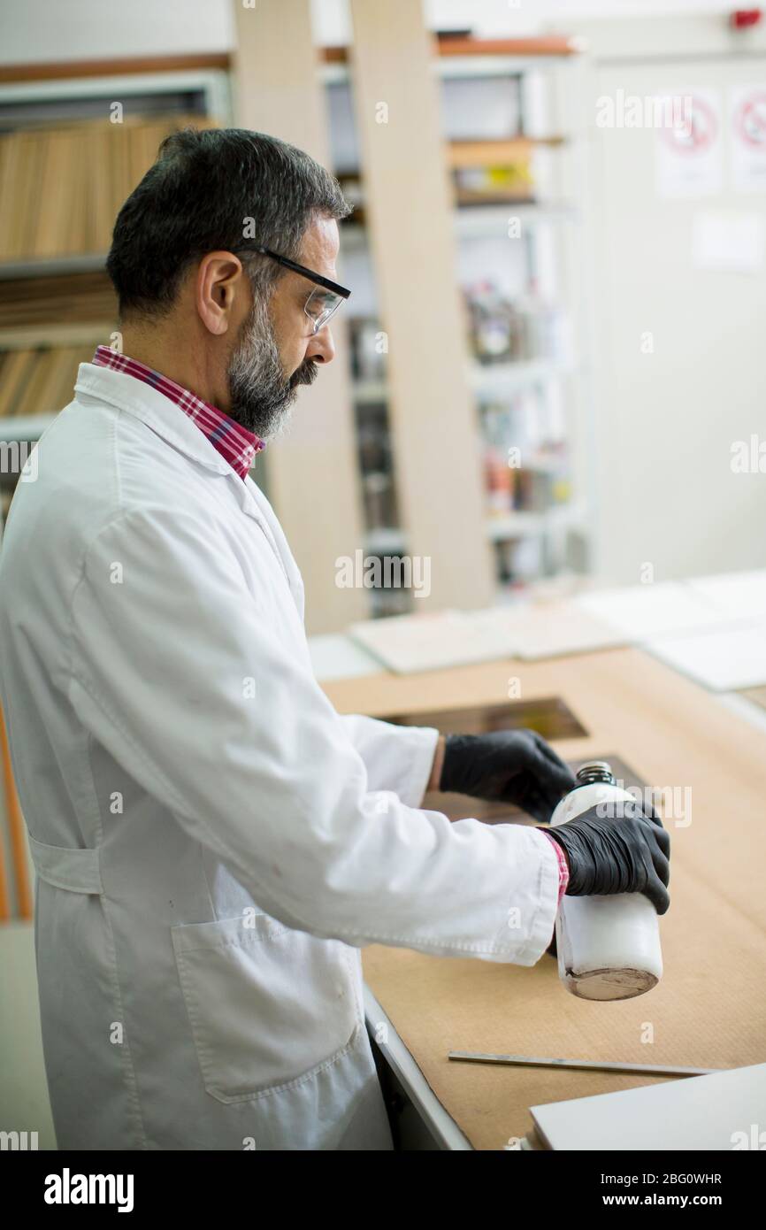 View at handsome mature engineer in the laboratory examines ceramic ...