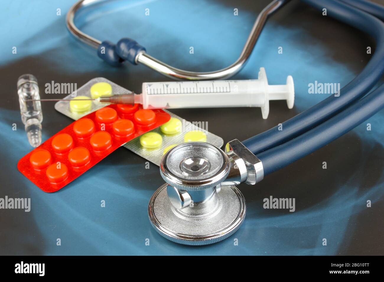 Medical stethoscope on x-ray picture with syringe and pills close up ...