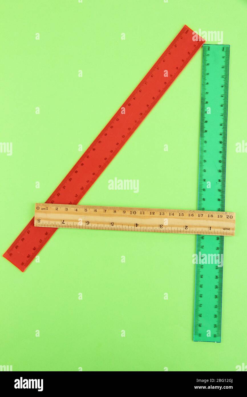 Rulers on green background Stock Photo - Alamy