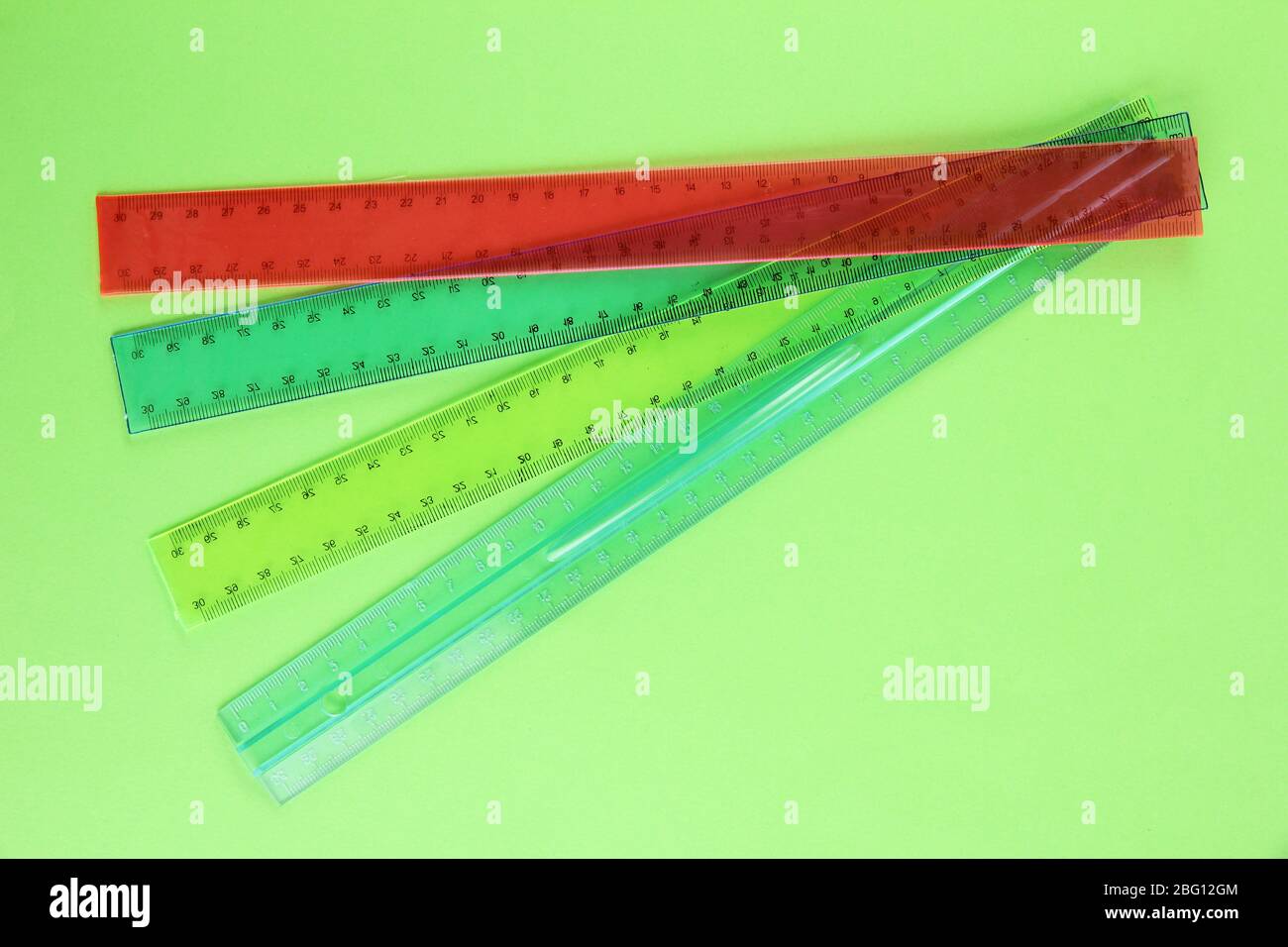 Rulers on green background Stock Photo - Alamy