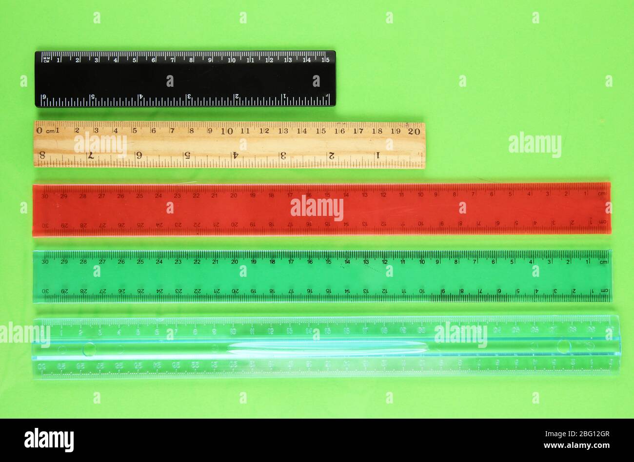 Rulers on green background Stock Photo - Alamy