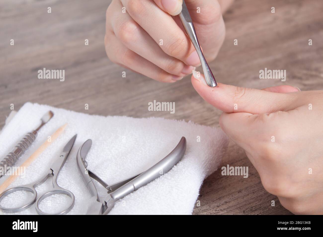 Manicure. Push back the cuticle with a metal pusher. Getting injured ...