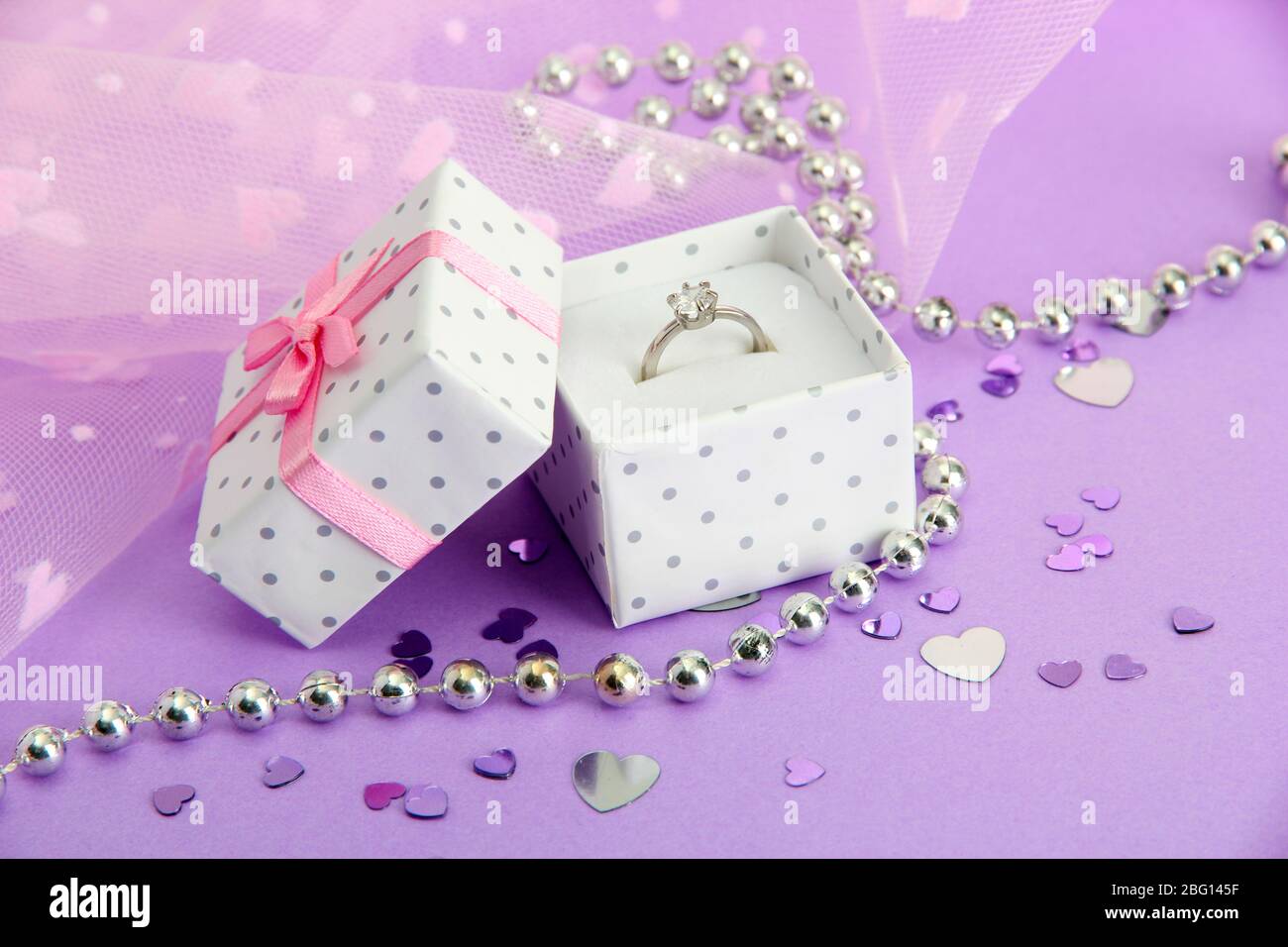 Beautiful box with wedding ring on purple background Stock Photo - Alamy