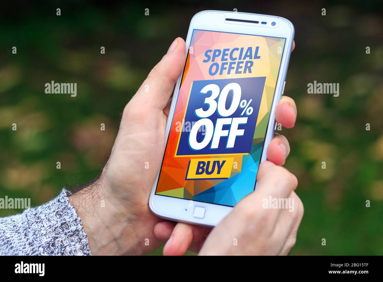 Man with a smartphone with a 30% discount advertising on the screen ...
