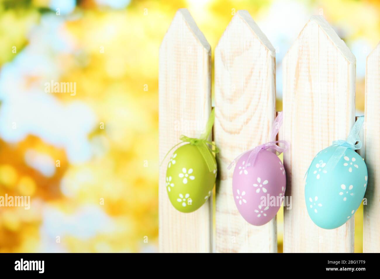 Art Easter background with eggs hanging on fence Stock Photo - Alamy