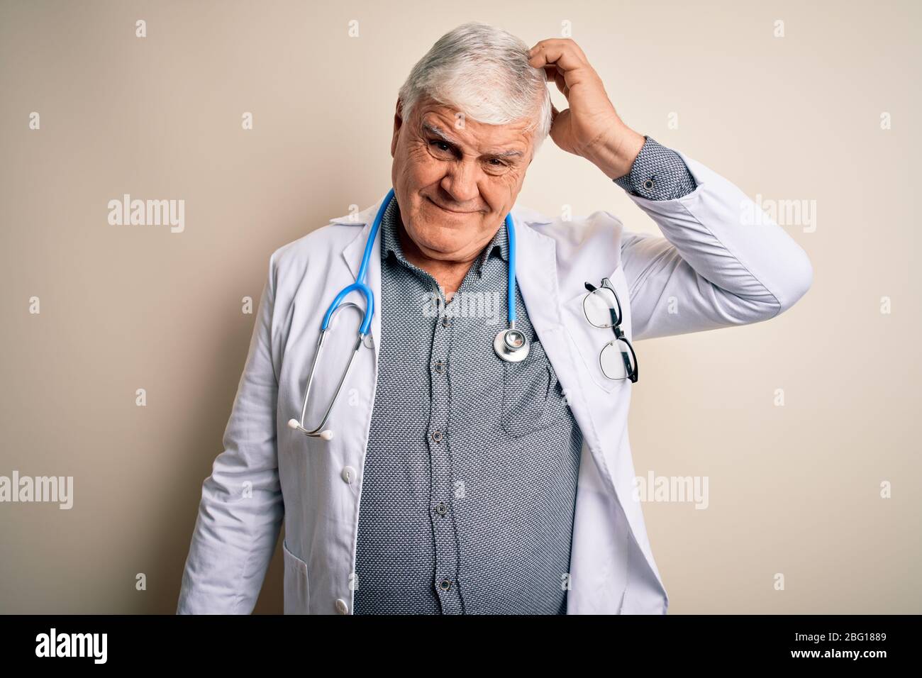 Senior handsome hoary doctor man wearing coat and stethoscope over ...