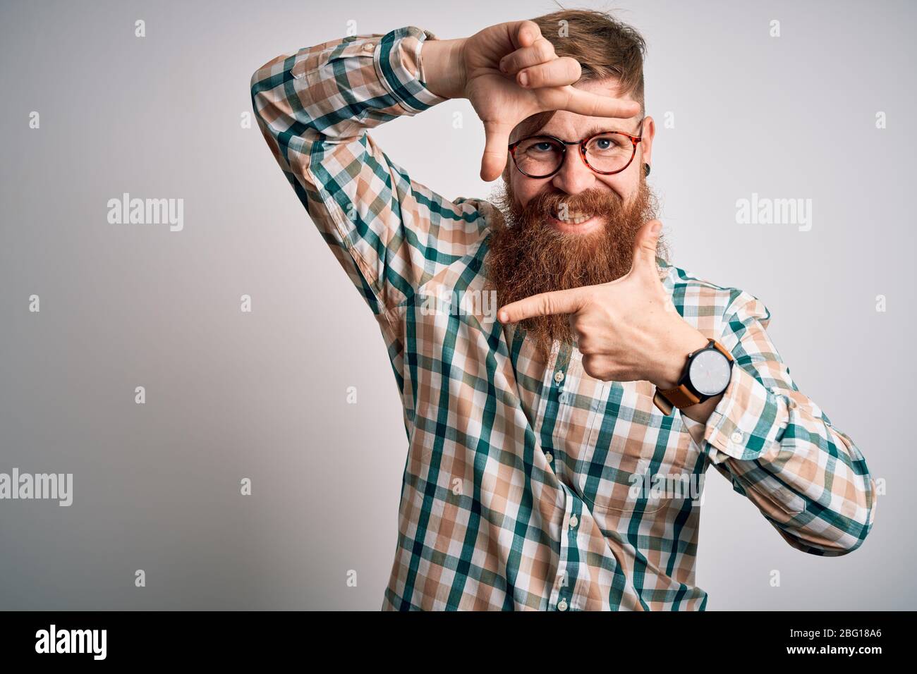 Handsome Irish redhead man with beard wearing glasses and hipster shirt ...
