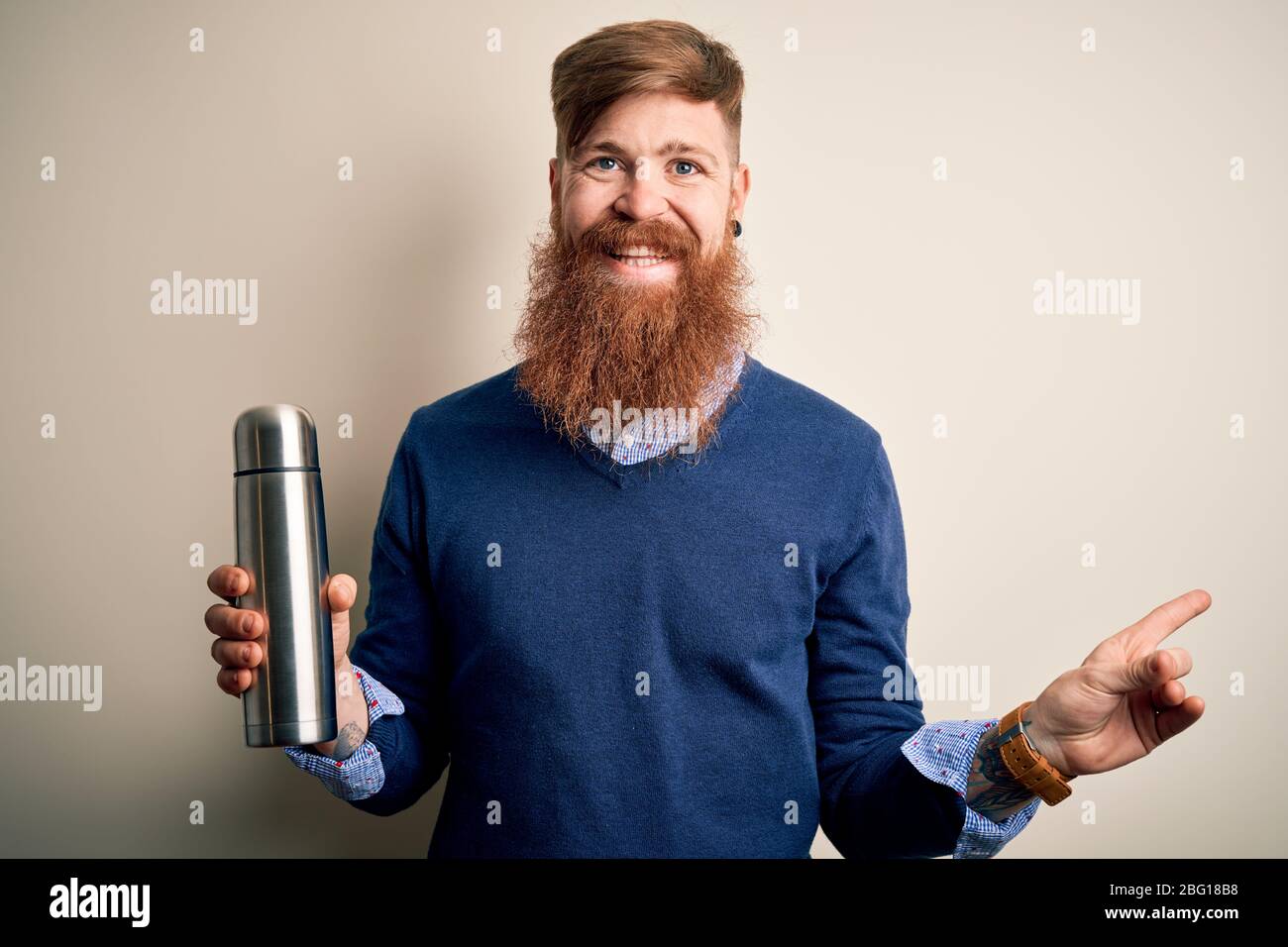 Redhead Irish man with beard holding takeaway beverage thermo over ...