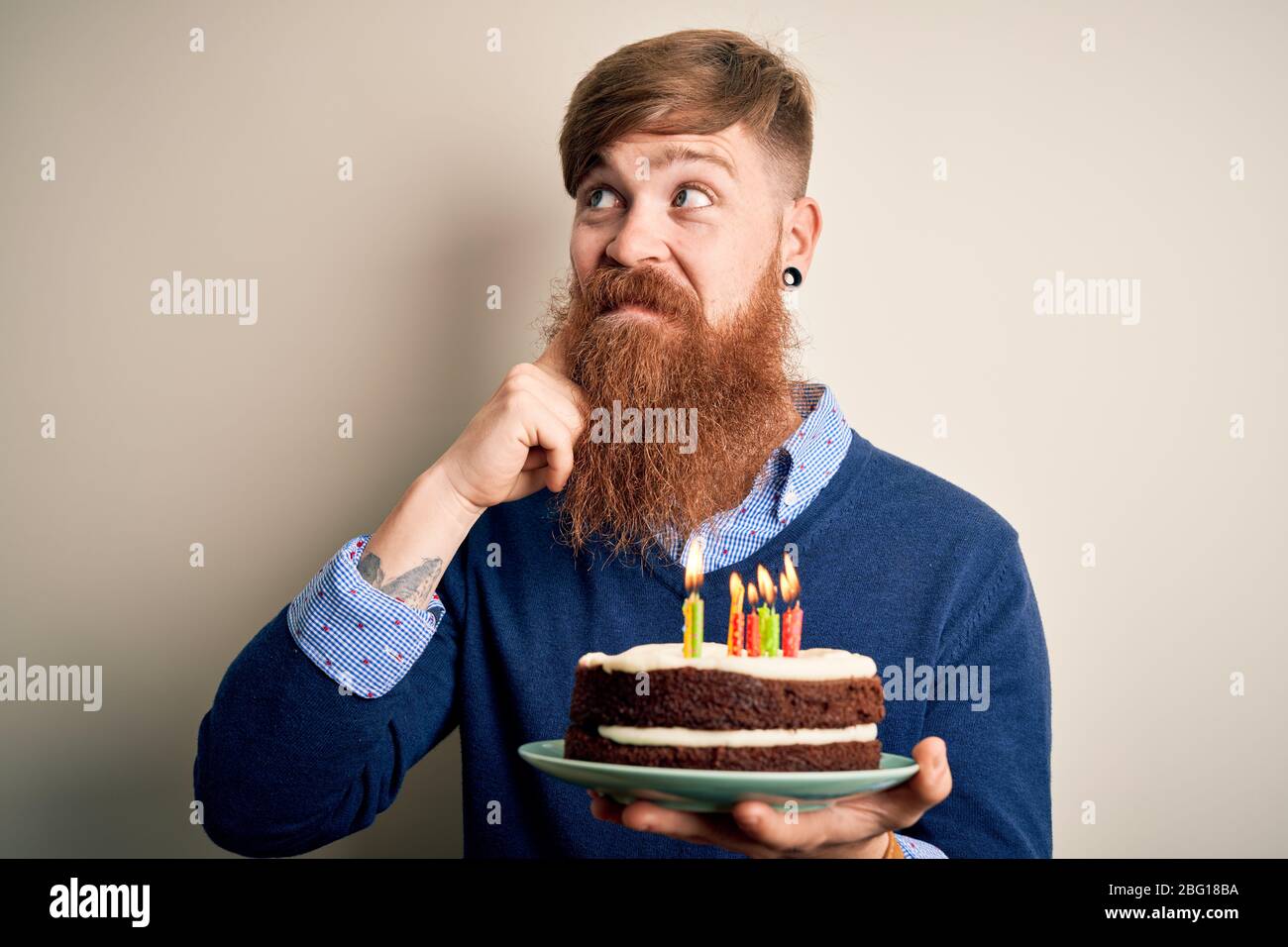 Irish redhead man with beard holding birthday cake with burning candles ...