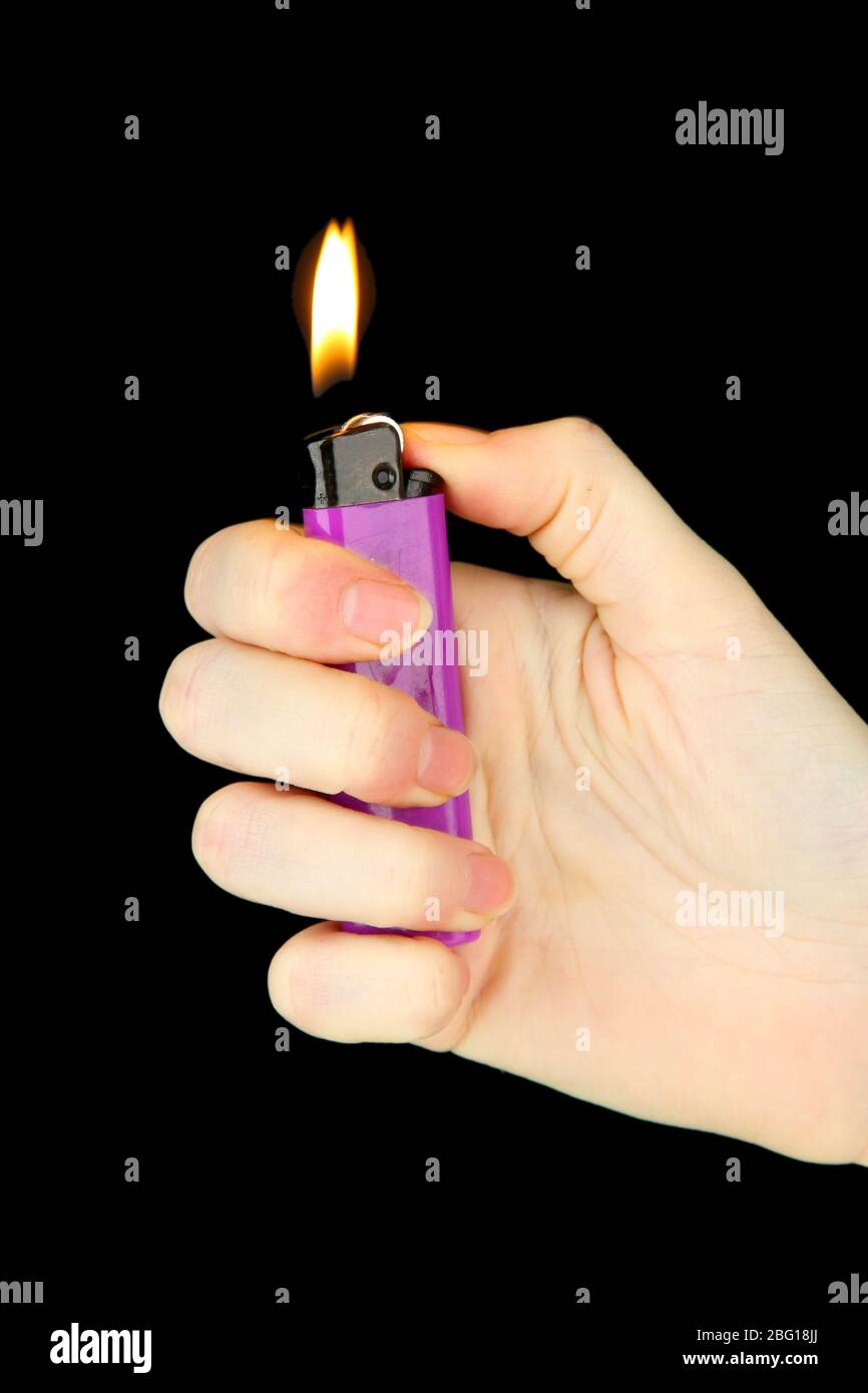 Burning lighter in female hand, isolated on black Stock Photo - Alamy