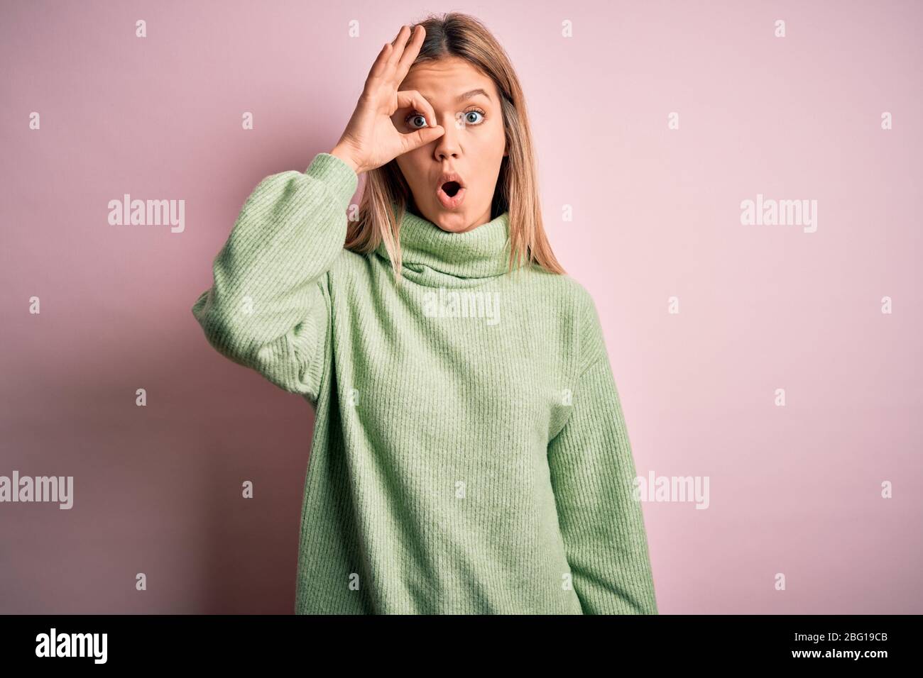 Young beautiful blonde woman wearing winter wool sweater over pink ...