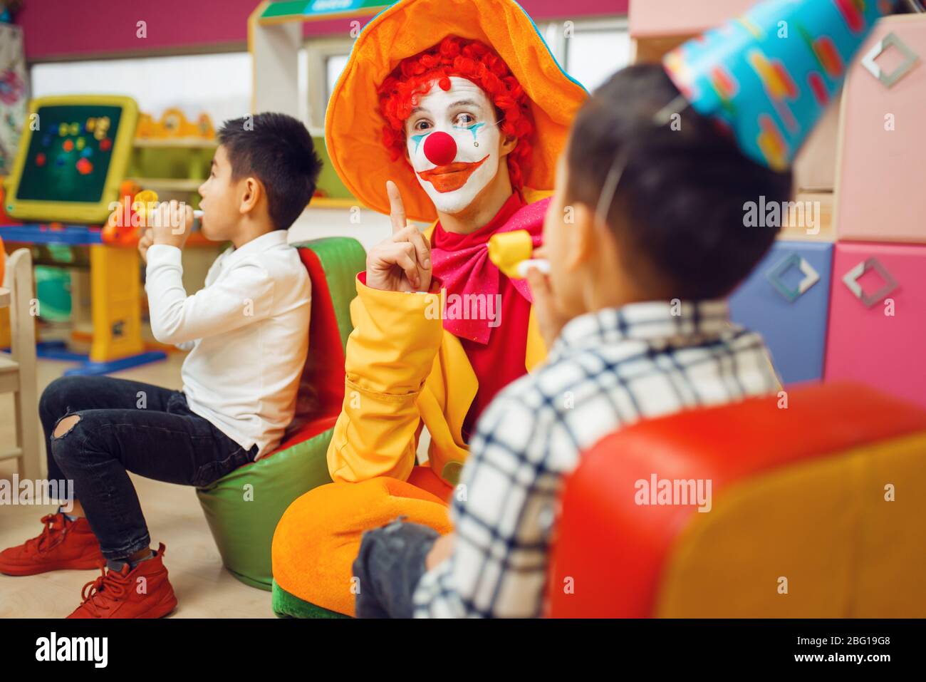 Funny clown play with cheerful children together Stock Photo - Alamy