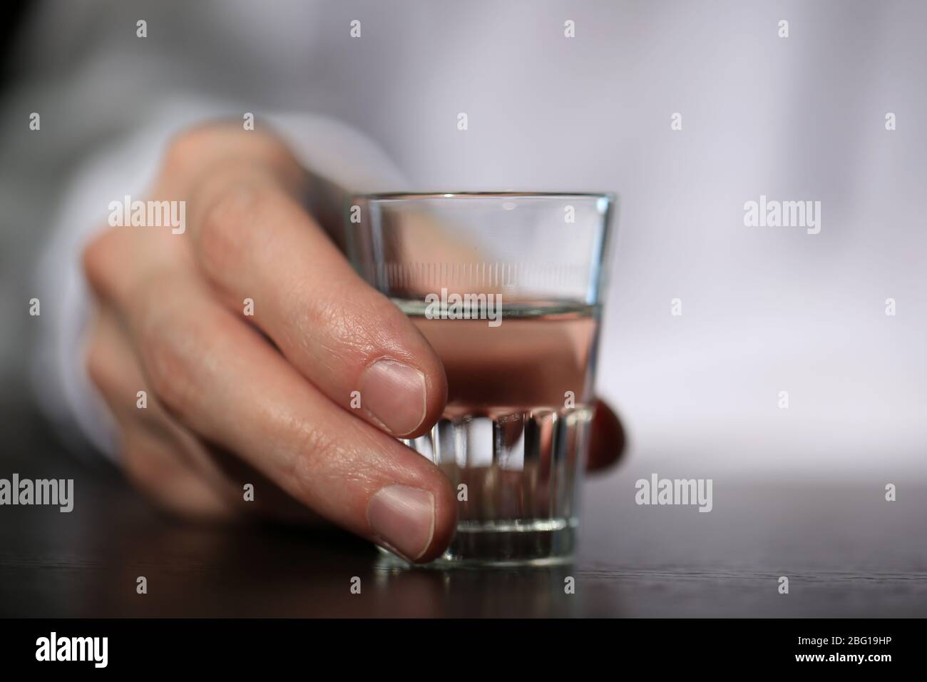Man hand with glass of vodka , close up Stock Photo - Alamy