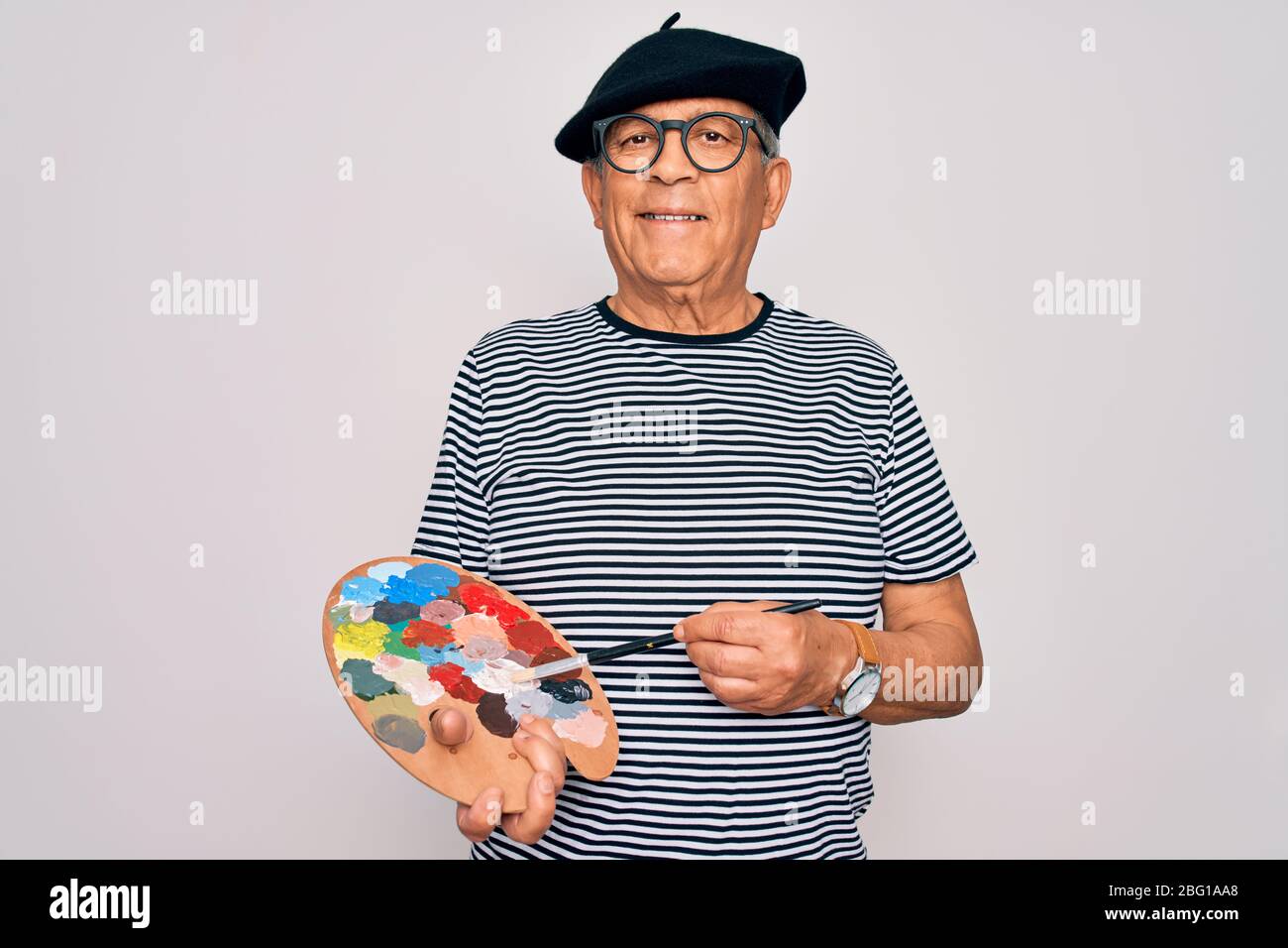 Senior hoary artist man wearing french beret drawing using paintbrush ...