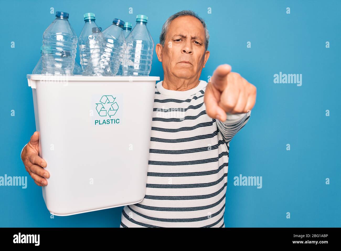 Senior man recycling holding trash can with plastic bottles to recycle ...