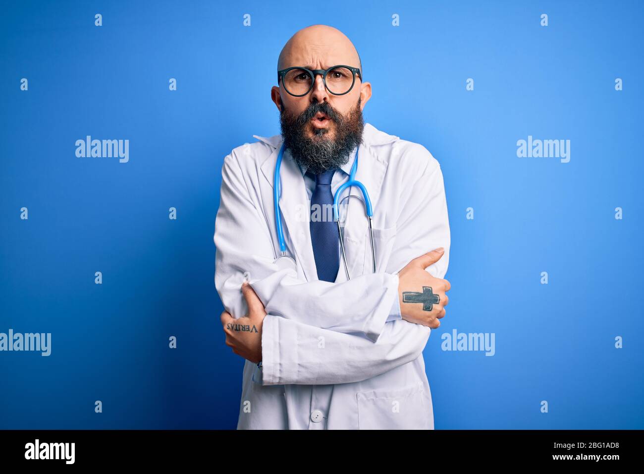 Handsome bald doctor man with beard wearing glasses and stethoscope ...