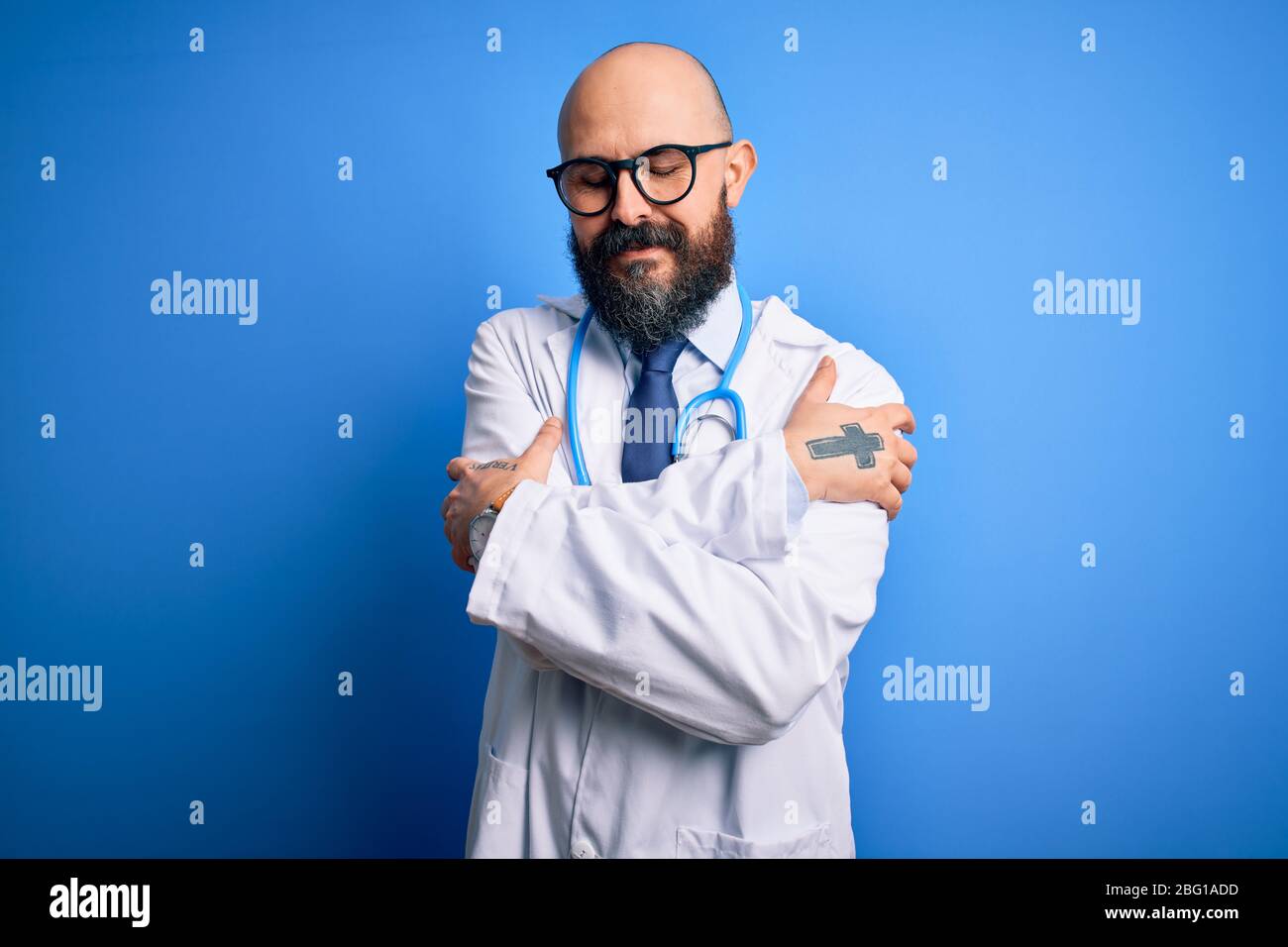 Handsome bald doctor man with beard wearing glasses and stethoscope ...