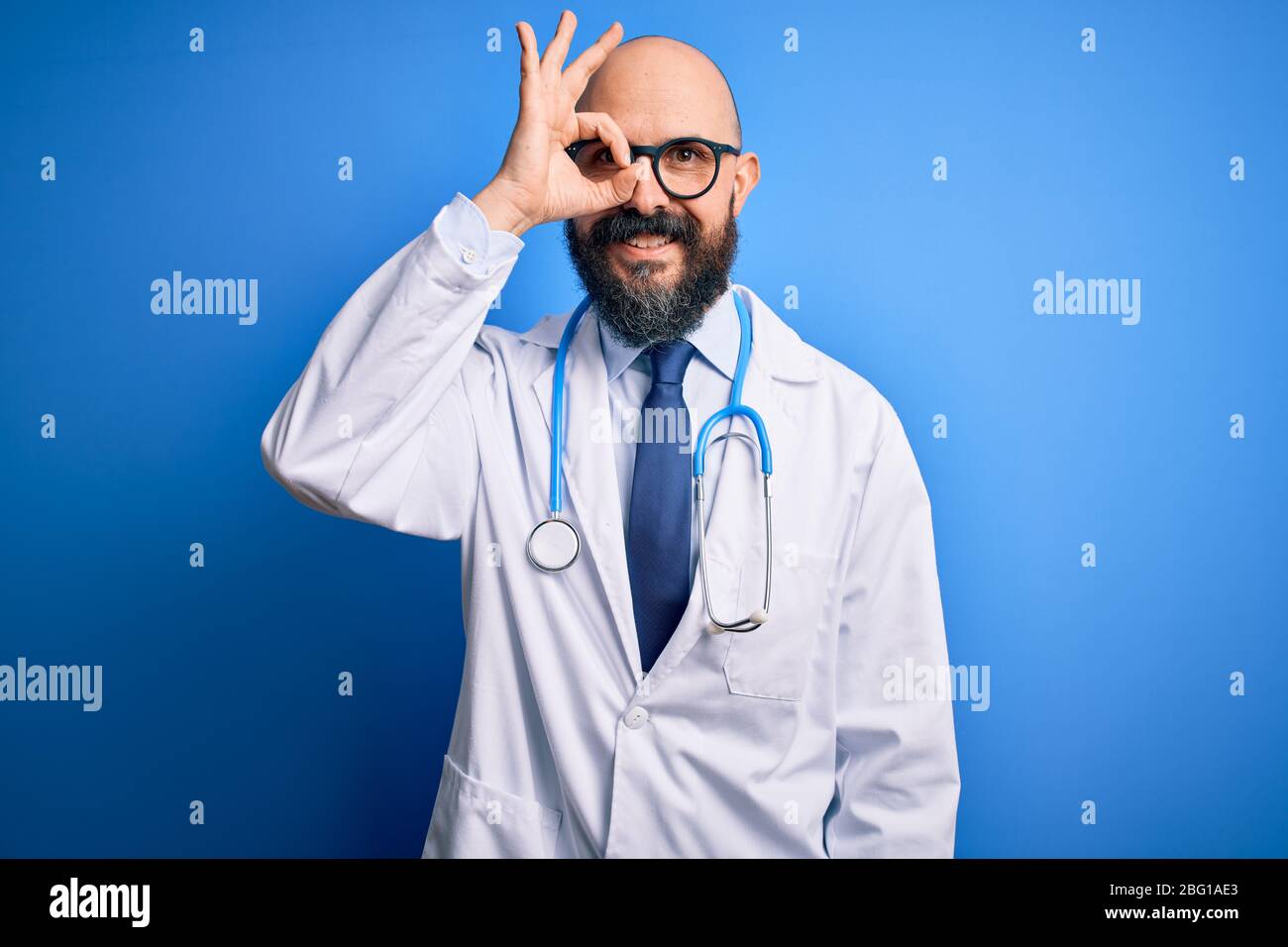 Handsome bald doctor man with beard wearing glasses and stethoscope ...