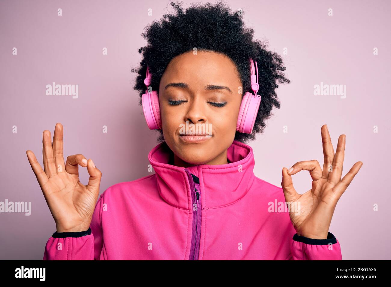 Young African American afro woman with curly hair listening to music ...